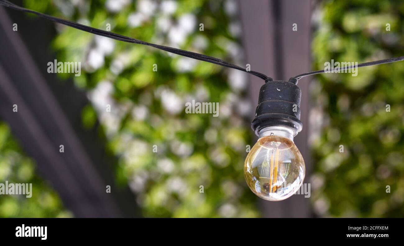 Lightbulb hanging outside Stock Photo - Alamy