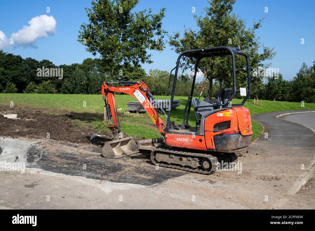 An orange Kubota KX015 4 mini excavator with cabin and digging bucket ...