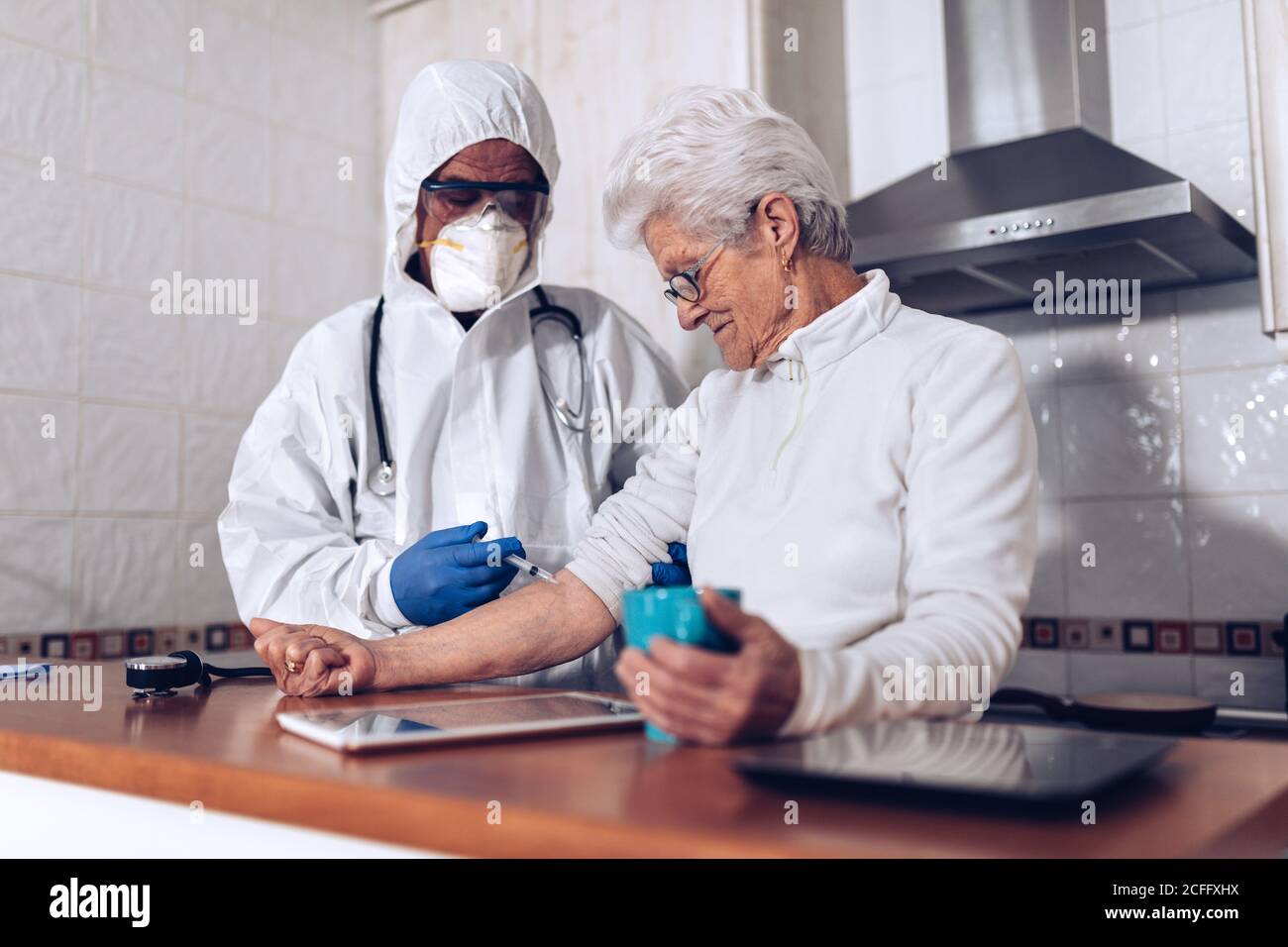 Caregiver making injection for senior patient at home Stock Photo - Alamy