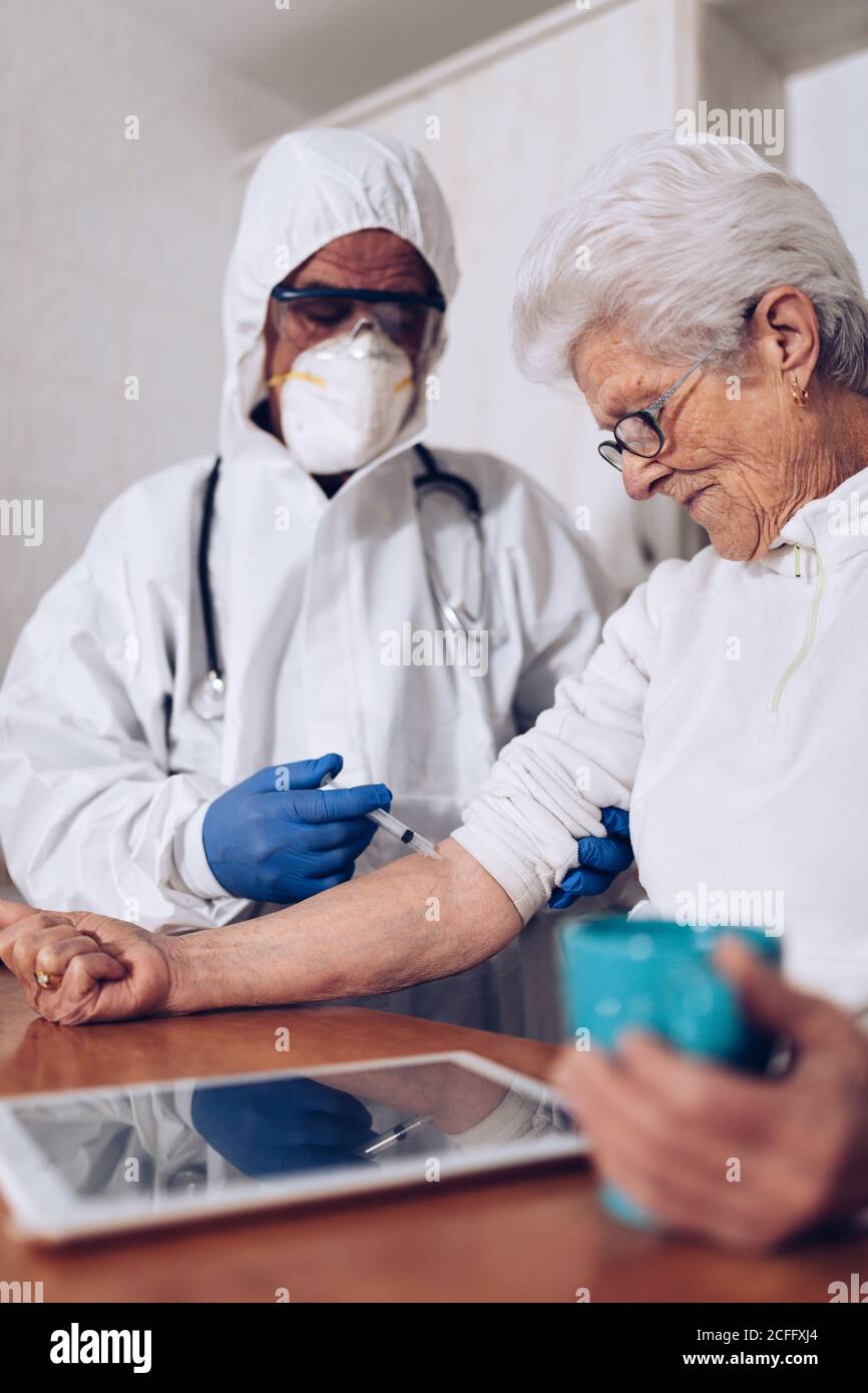 Caregiver making injection for senior patient at home Stock Photo - Alamy