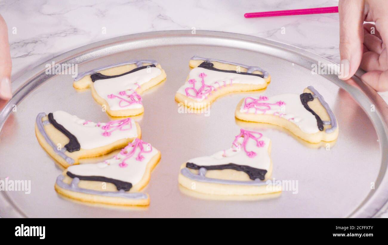 Brushing edible glitter on iced figure skate sugar cookies Stock Photo ...