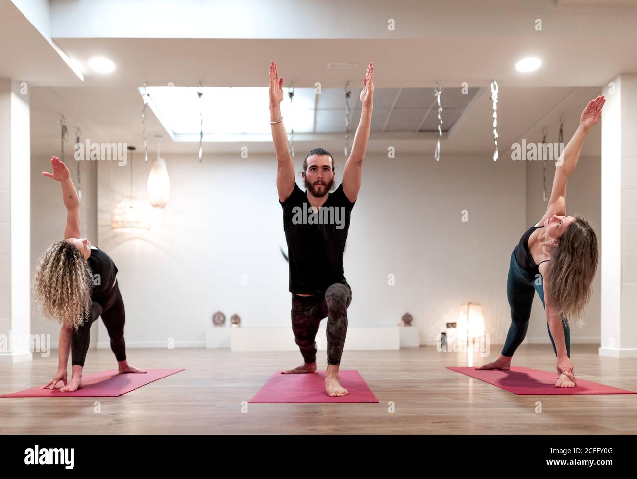 Balanced calm women and man concentrated on stretching and raising ...