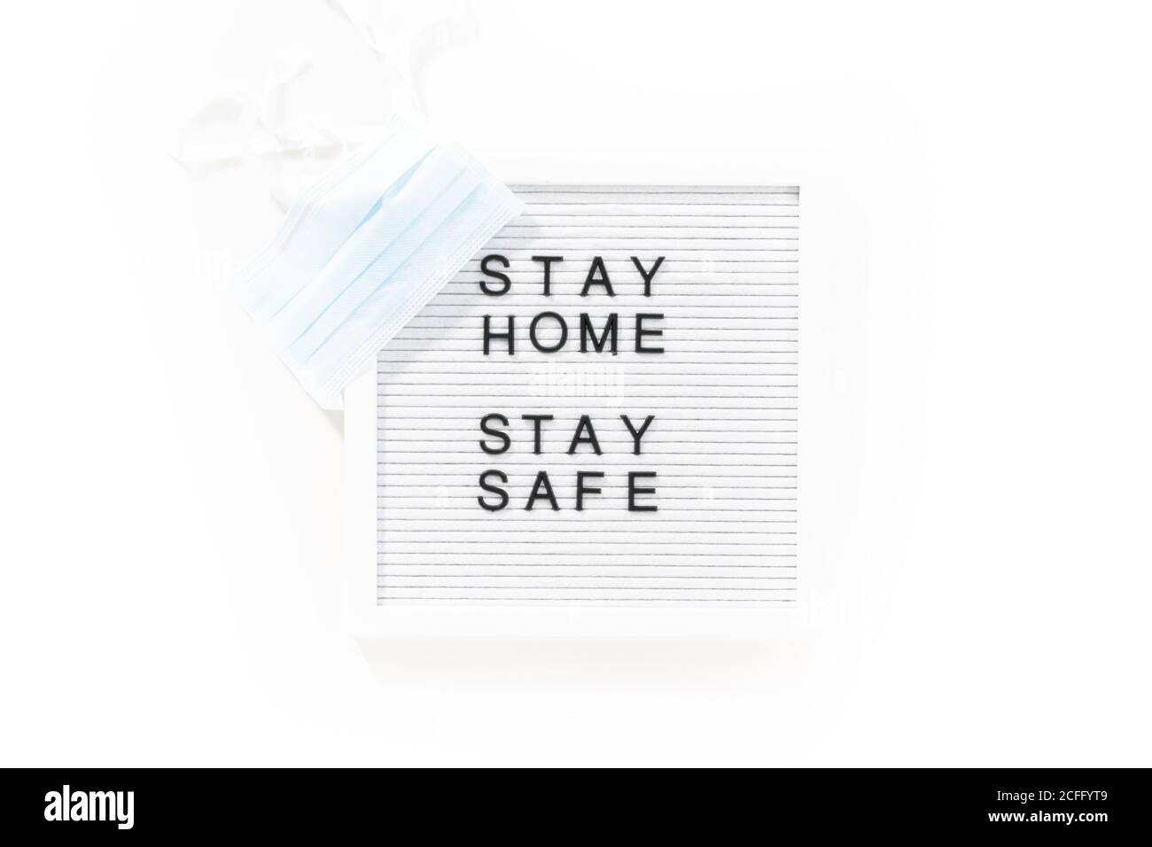 STAY HOME and STAY SAFE sign on message board with a blue medical mask ...