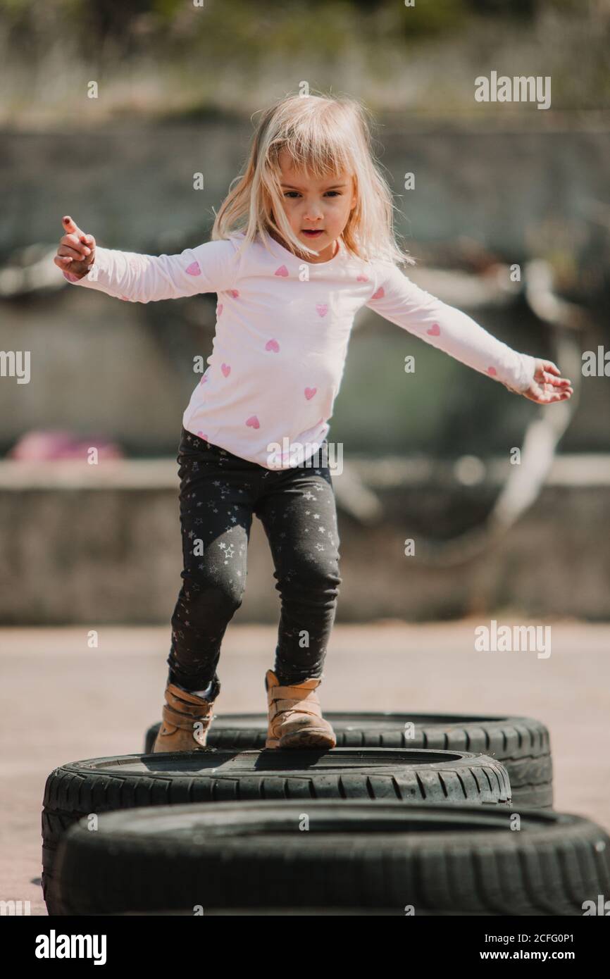Happy joyful little girl having fun and walking through row of black ...