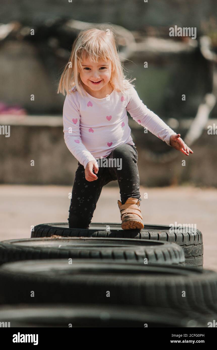 Happy joyful little girl having fun and walking through row of black ...