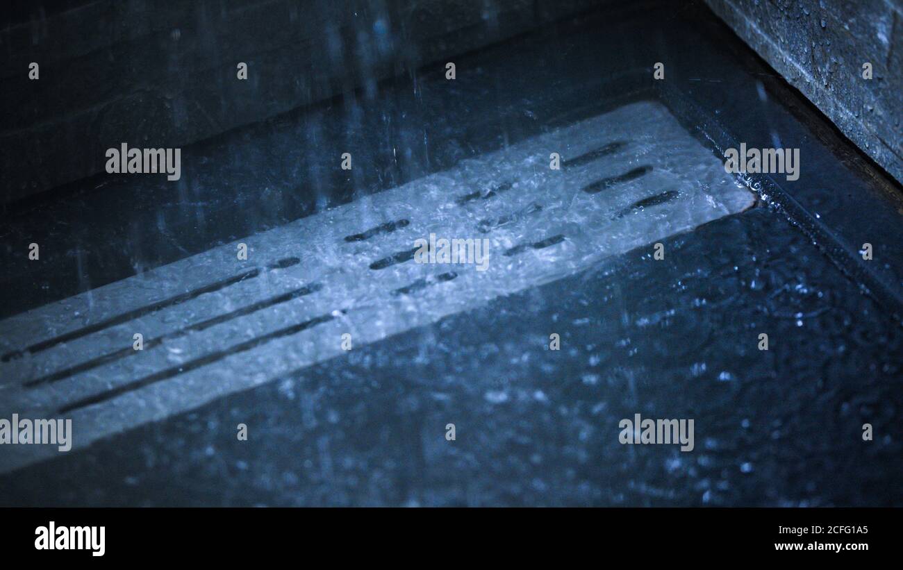 From above streams of water falling on floor and flowing into drain in ...