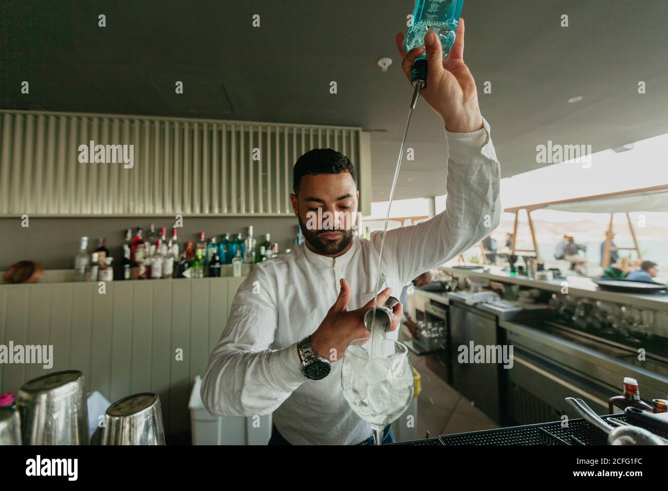 Cheerful man preparing alcoholic drinks in a bar Stock Photo - Alamy
