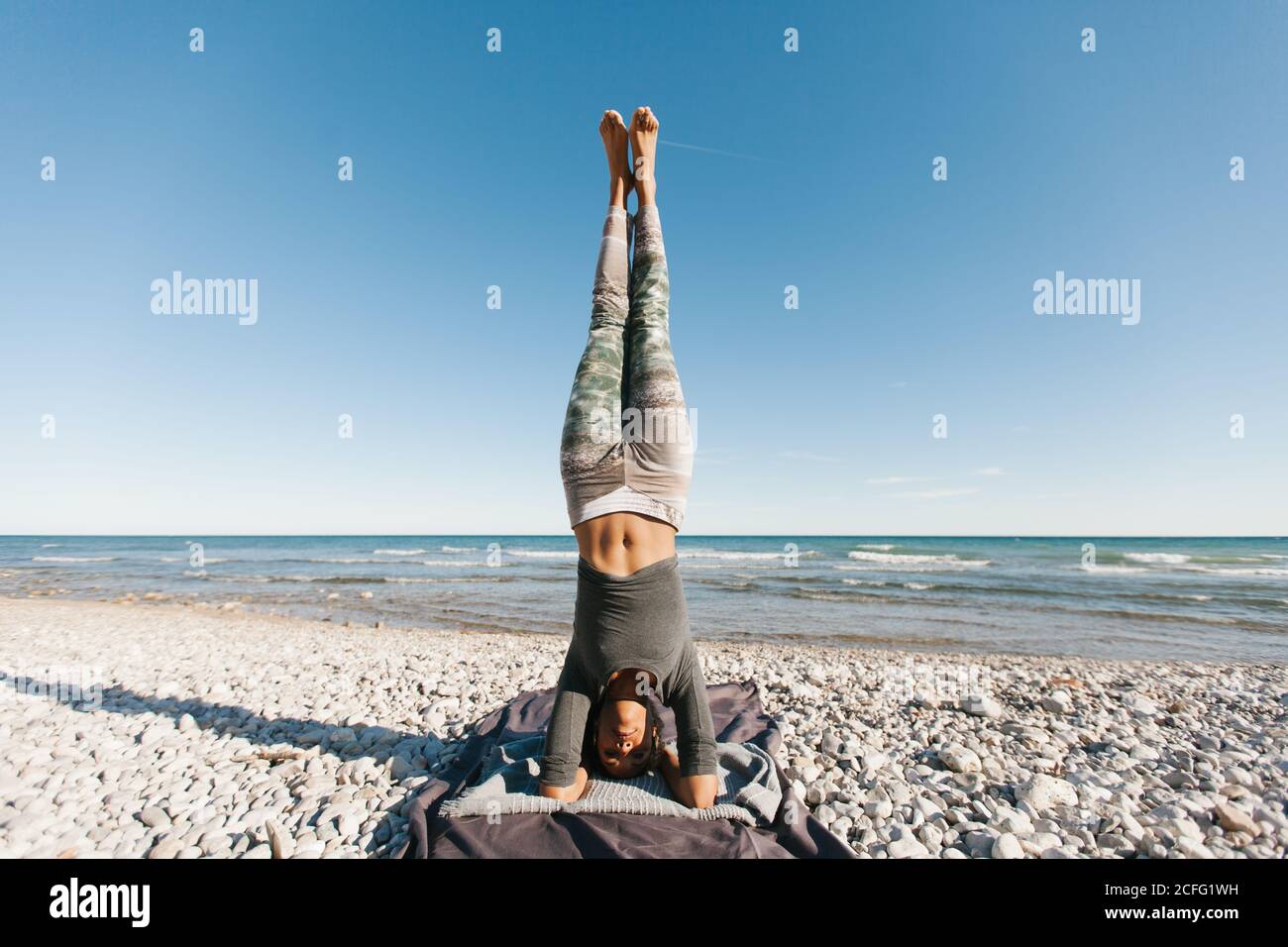 African American attractive young Woman in yoga headstand posture in ...