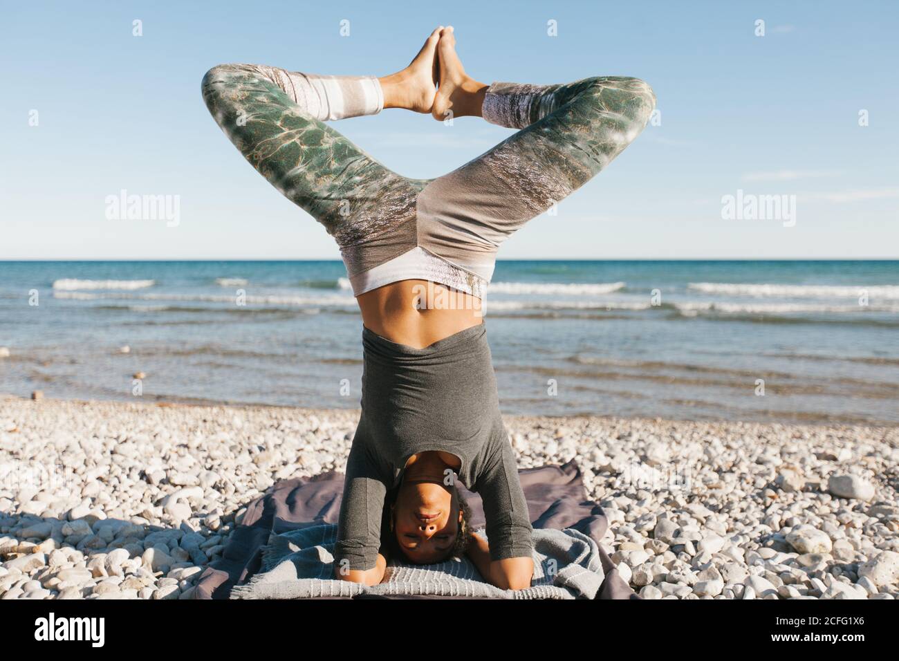 African American attractive young Woman in yoga headstand posture in ...