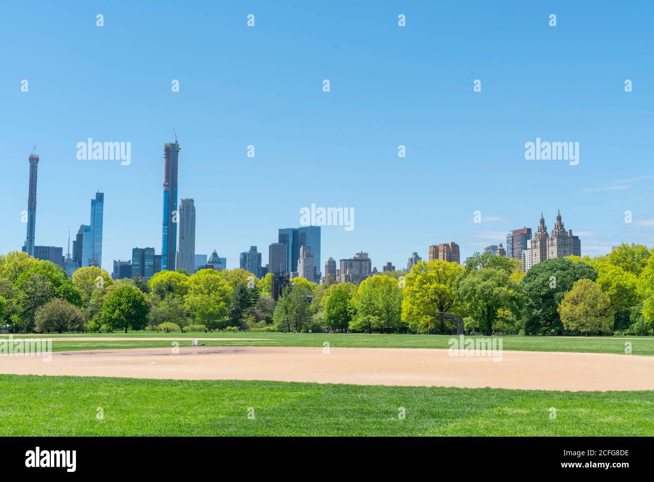 Manhattan skyscraper stands behind the fresh green trees in Central ...
