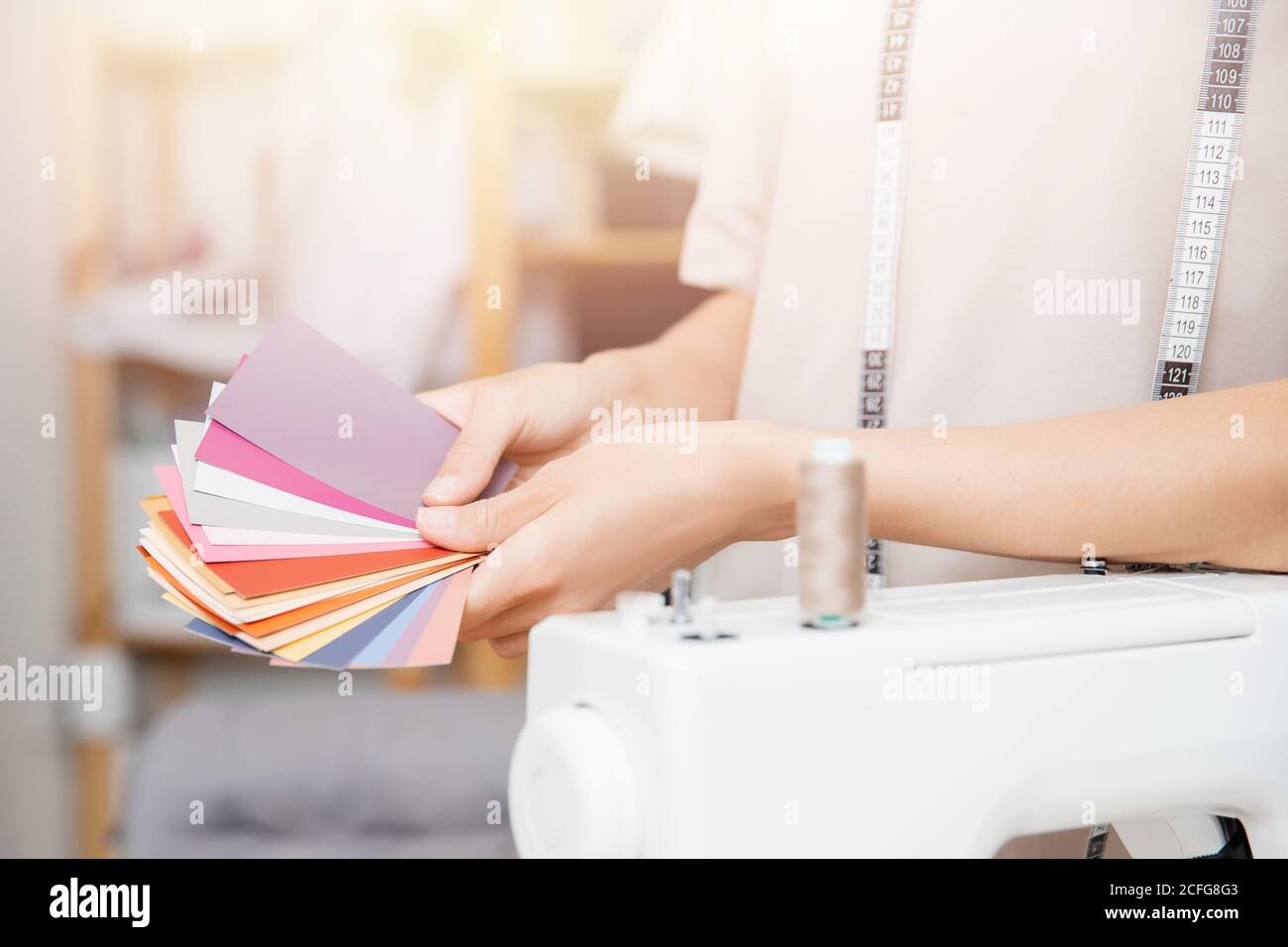 Choosing shade of fabric for sewing clothes, woman fashion designer is ...