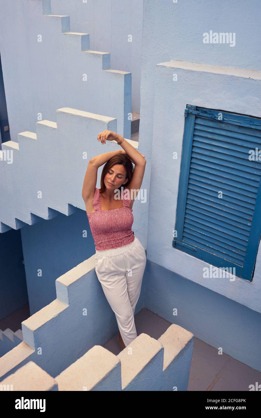 From above top view of young Woman walking upstairs on modern blue ...