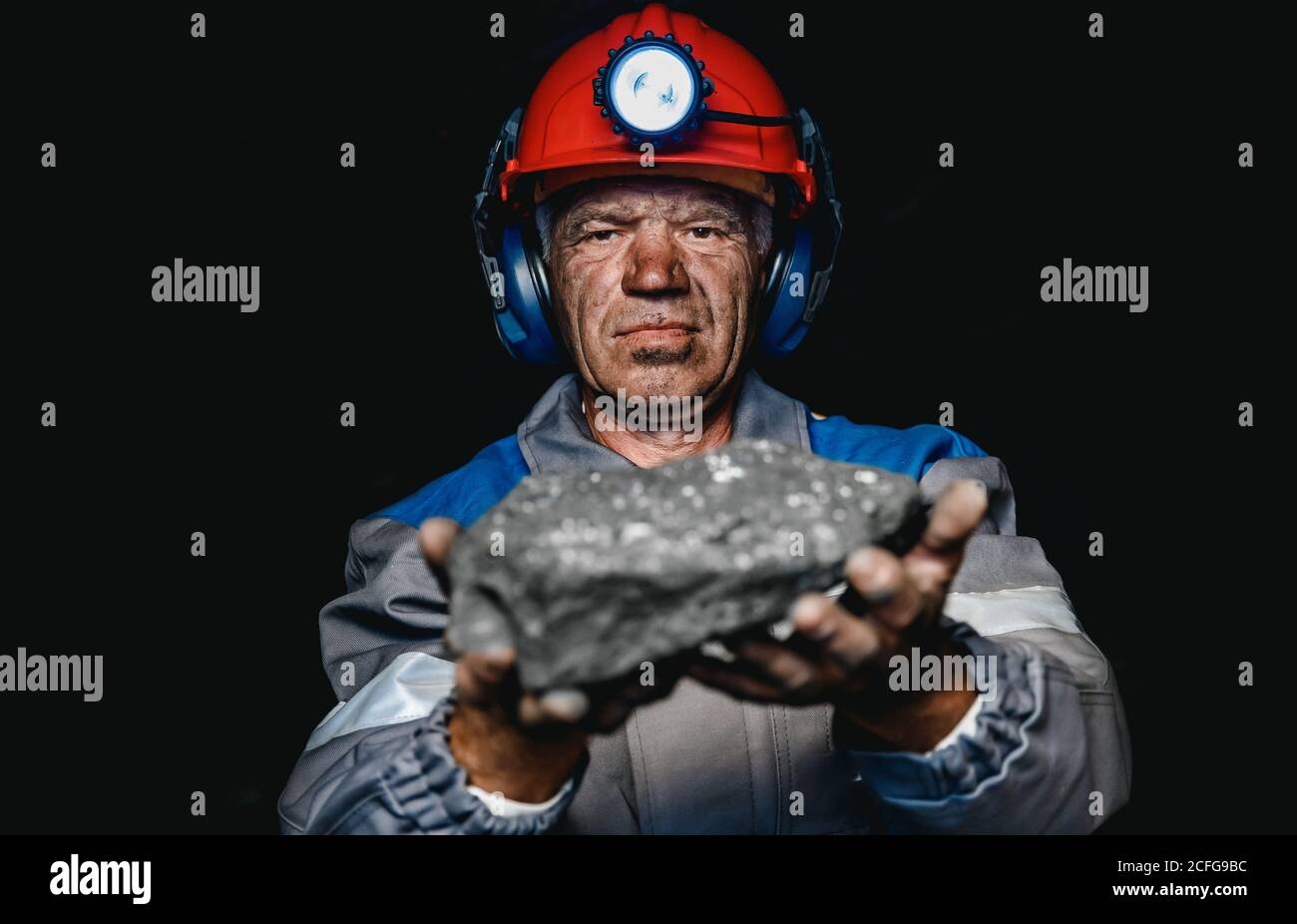 Miner man worker holds coal palm. Concept mining Stock Photo - Alamy