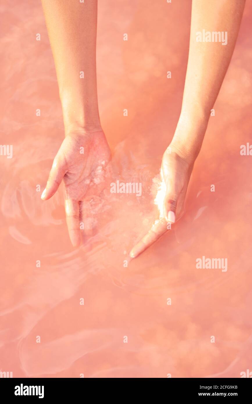 Female holding healing salt pile in pink water Stock Photo - Alamy