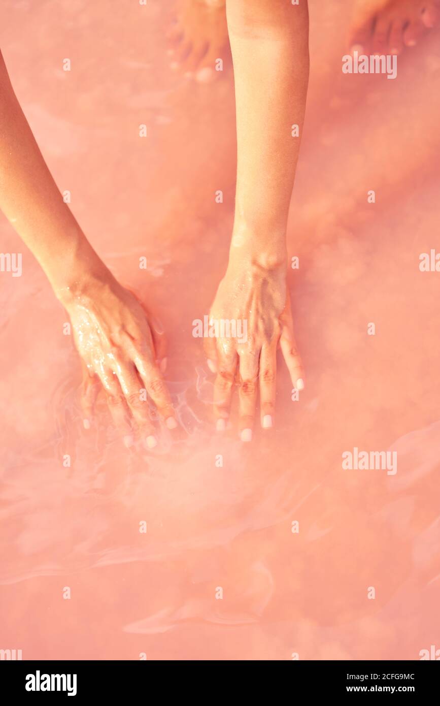 Female holding healing salt pile in pink water Stock Photo - Alamy