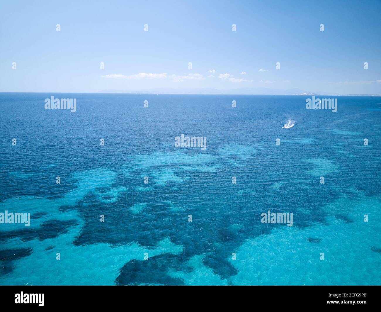 aerial view of sardinia shoreline with boat and crystal clear blue ...