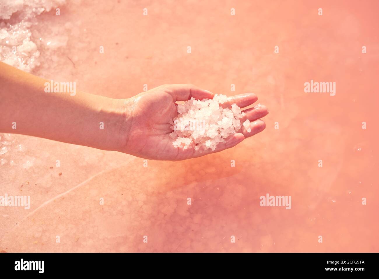 Female holding healing salt pile in pink water Stock Photo - Alamy