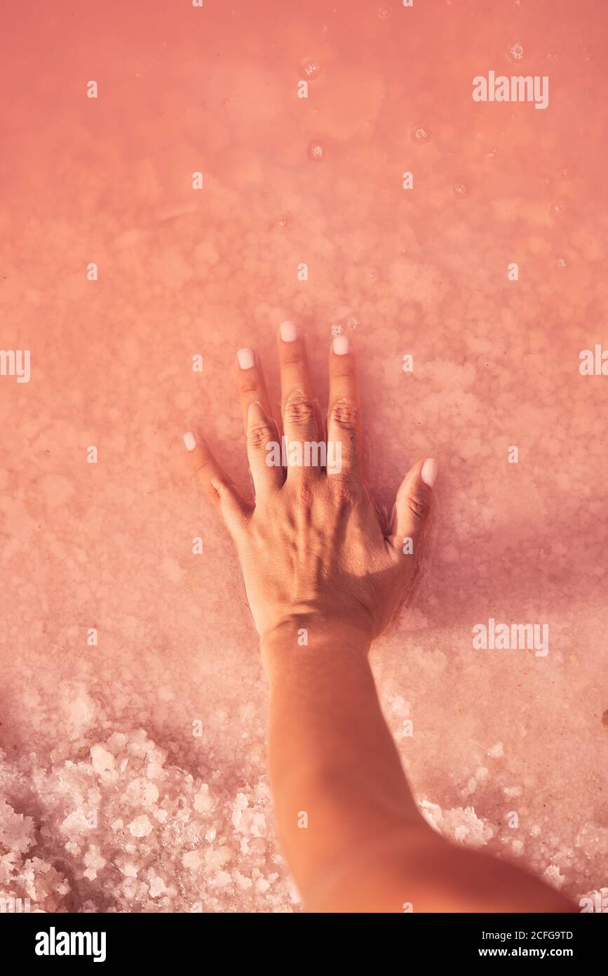 Female holding healing salt pile in pink water Stock Photo - Alamy