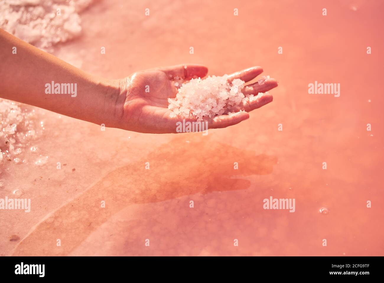 Female holding healing salt pile in pink water Stock Photo - Alamy