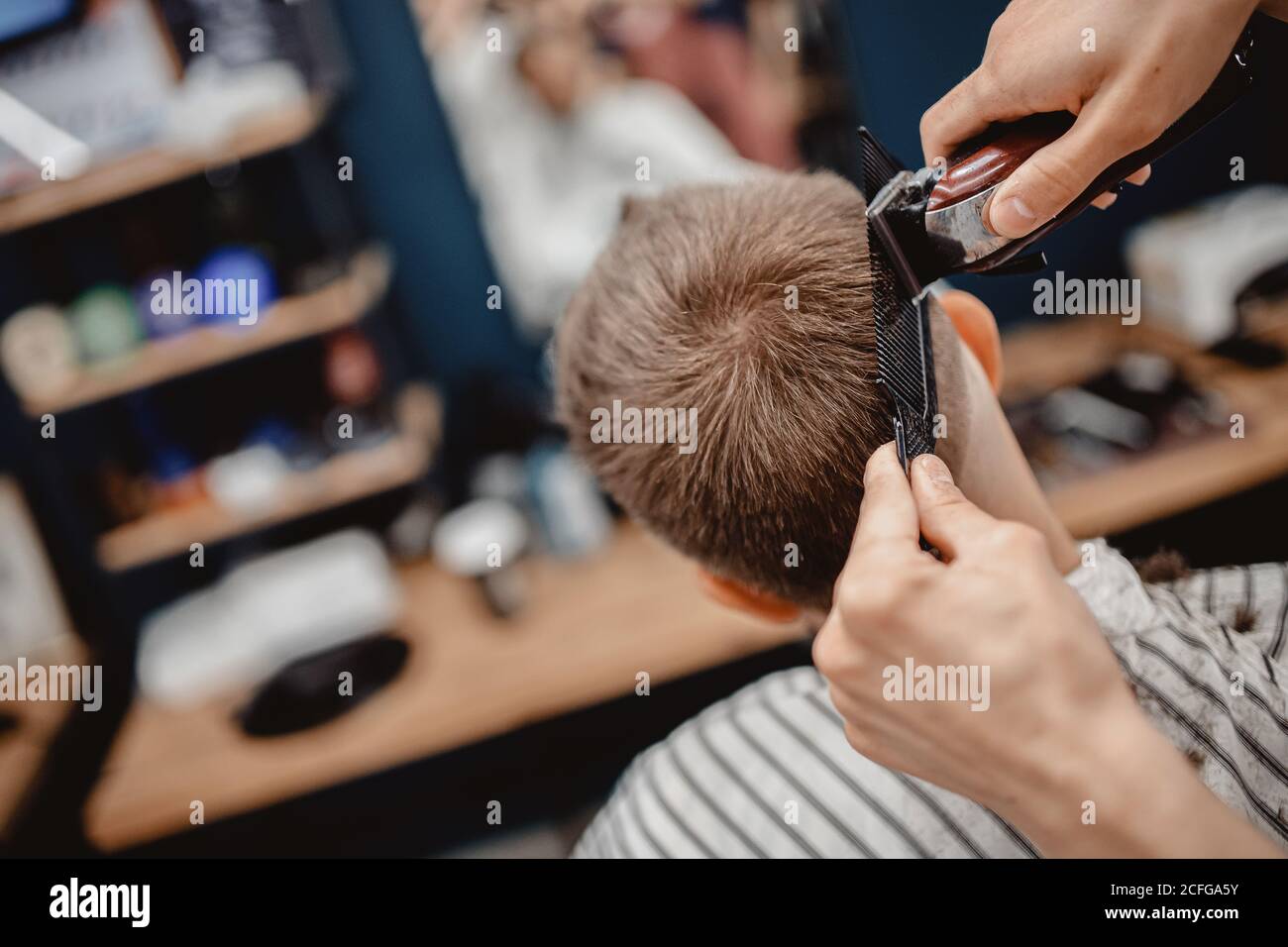Barber in Barbershop shear hair electric to young guy for fashionable ...