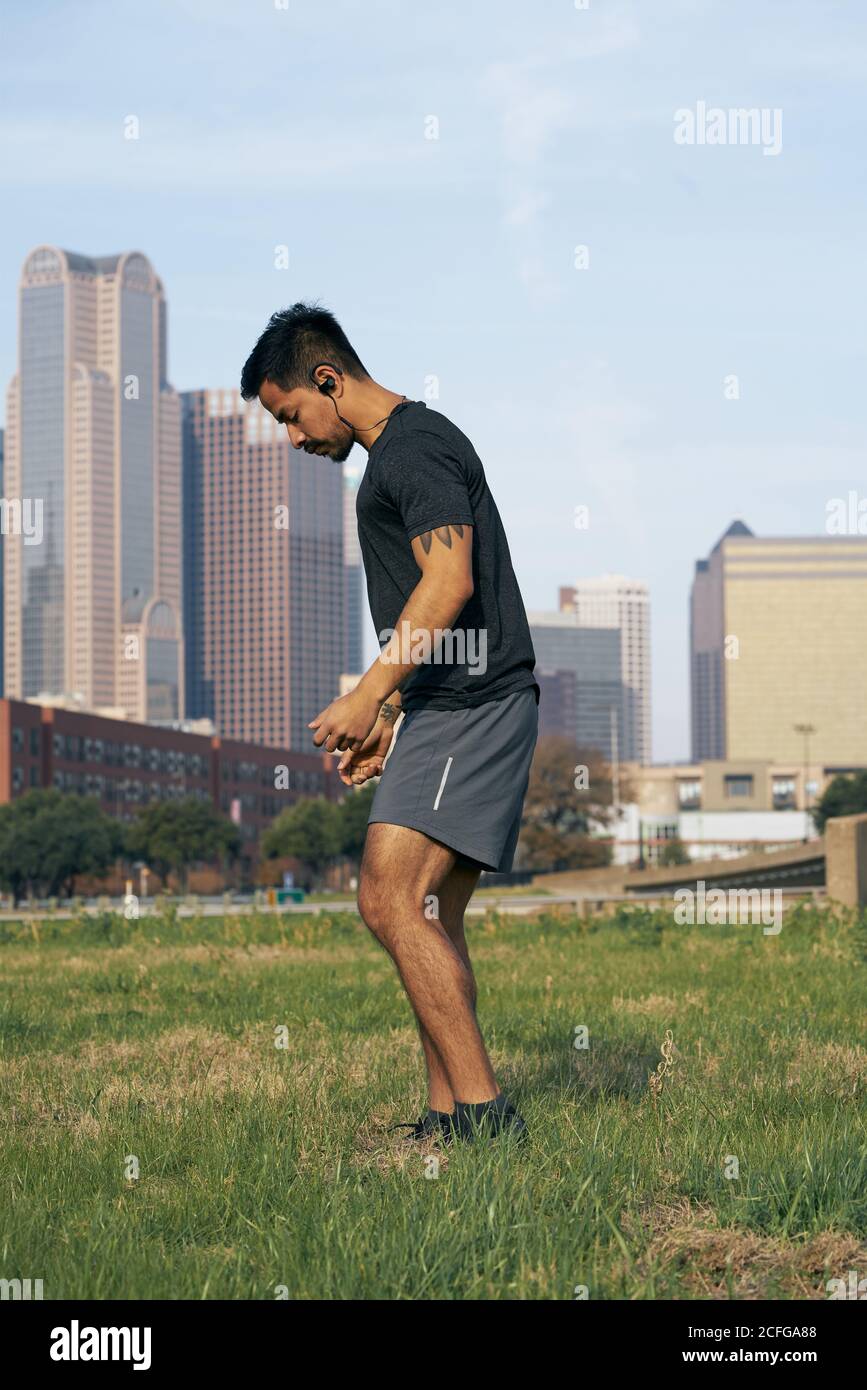 Side view of Hispanic male athlete in active wear jumping with ...