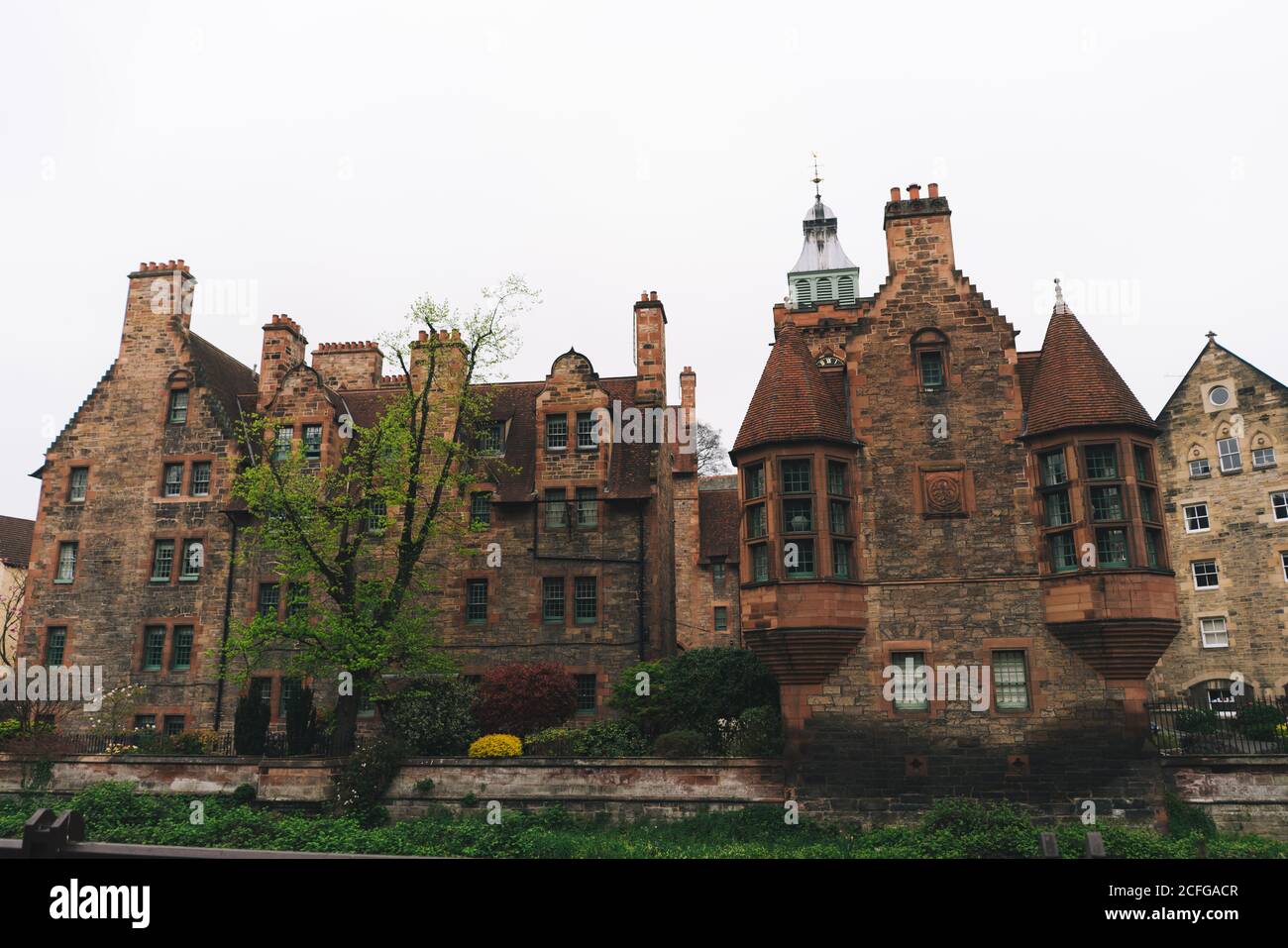 Landscape of old masonry buildings flowing among green bushes, Scotland ...