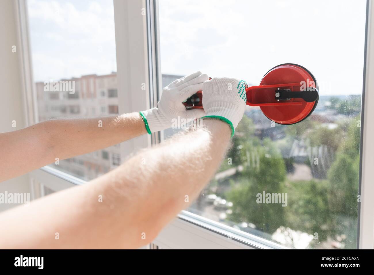 Worker man installs upvc plastic windows using suction cup Stock Photo ...