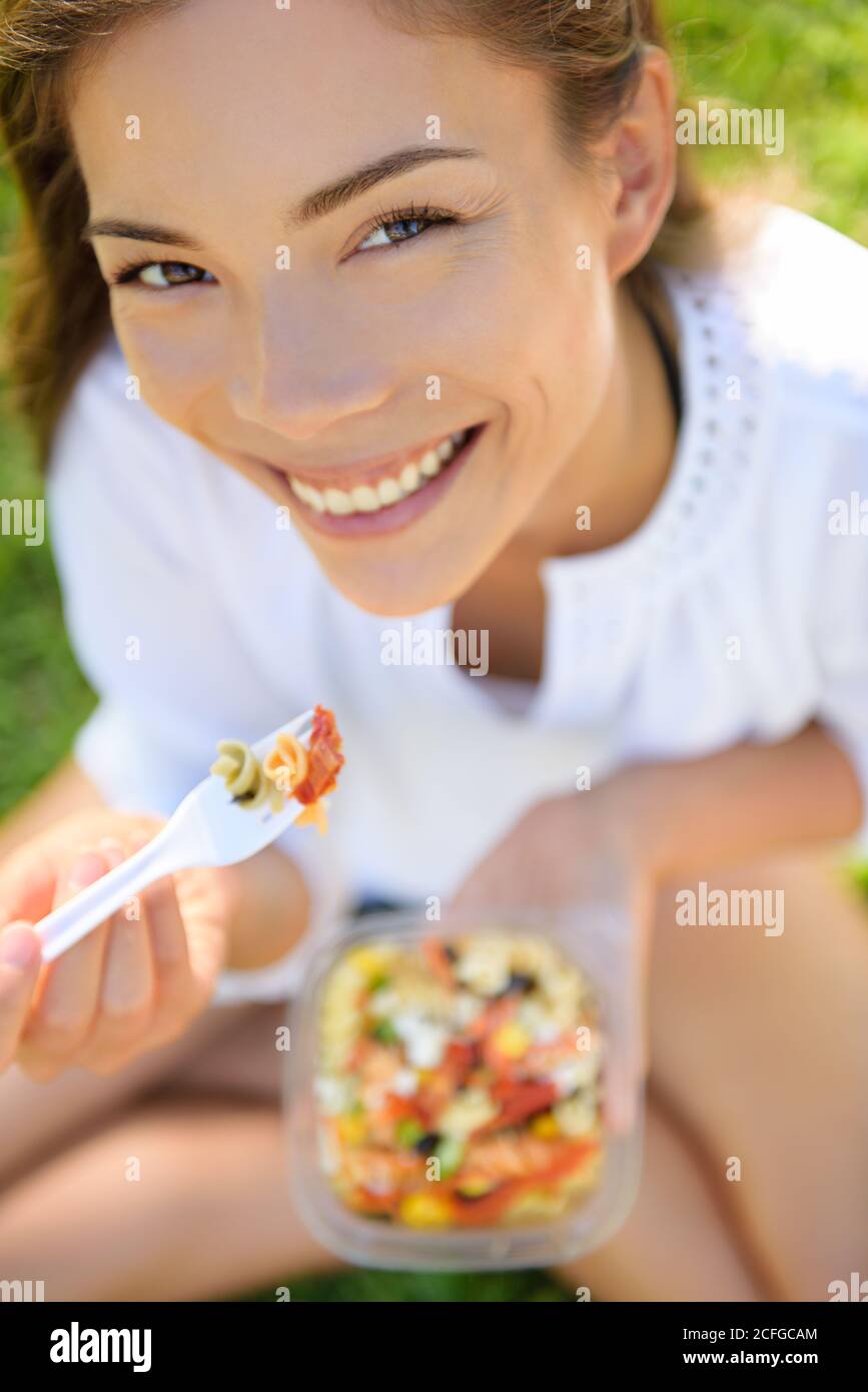Woman eating gluten free pasta salad Stock Photo - Alamy