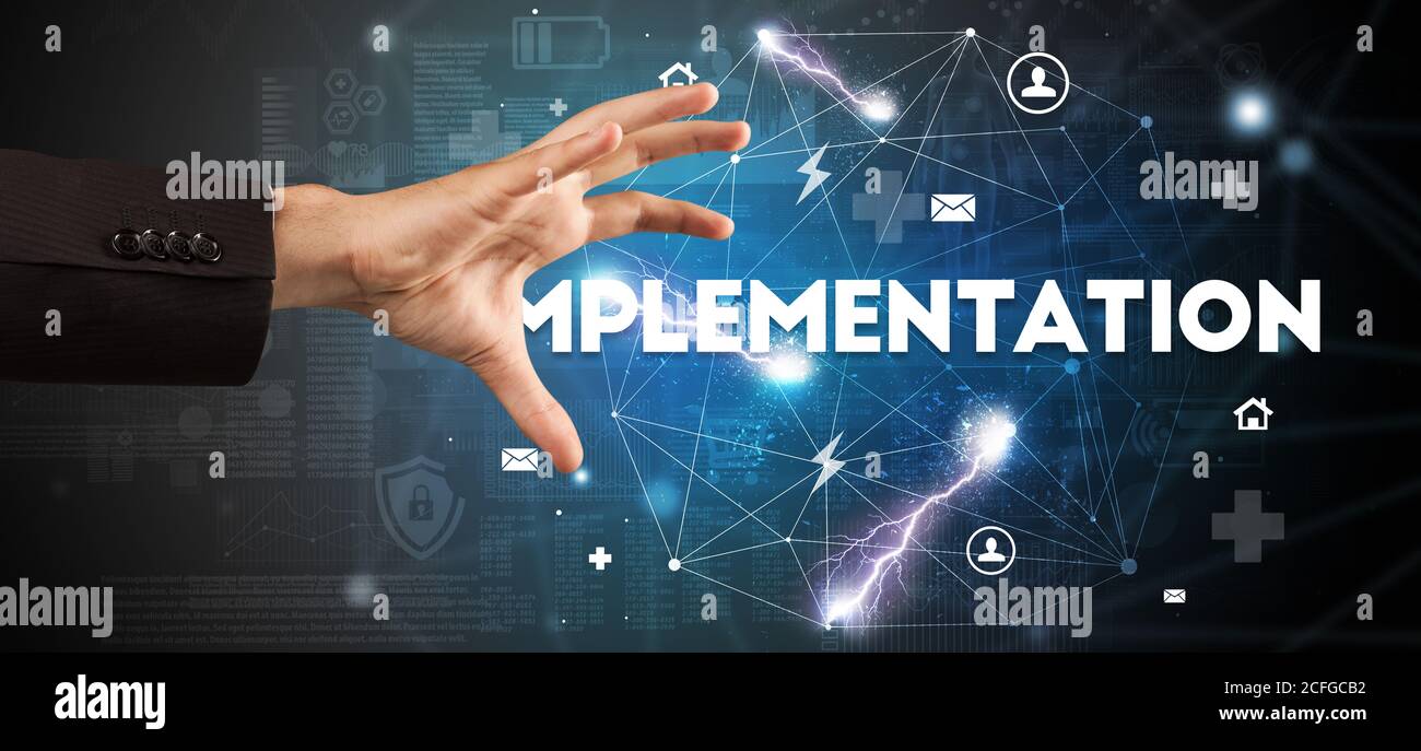 Hand pointing at IMPLEMENTATION inscription, modern technology concept ...