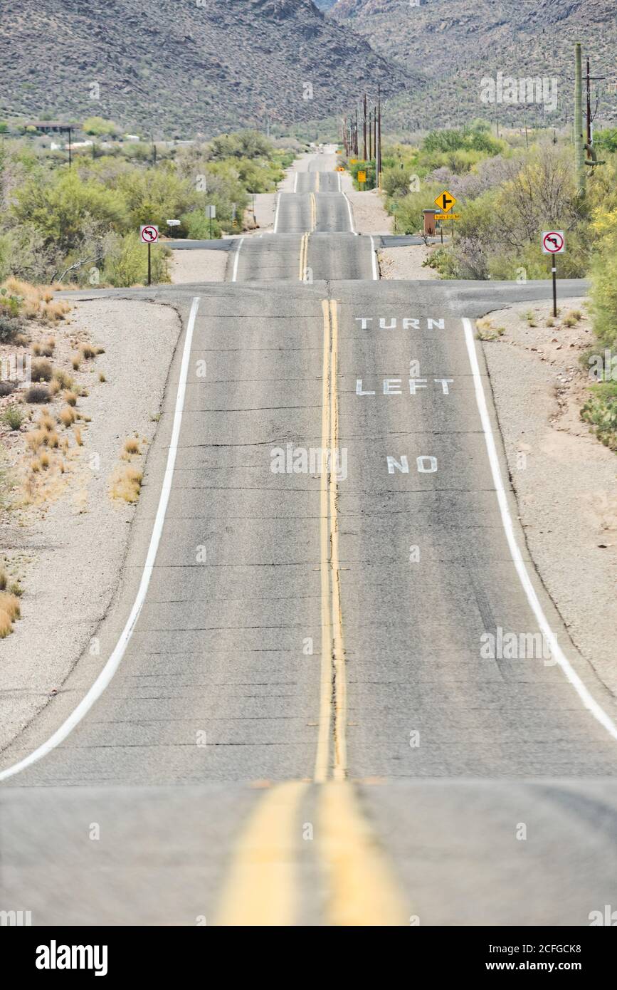 Rural highway at dusty field with power line and remote mountain range ...