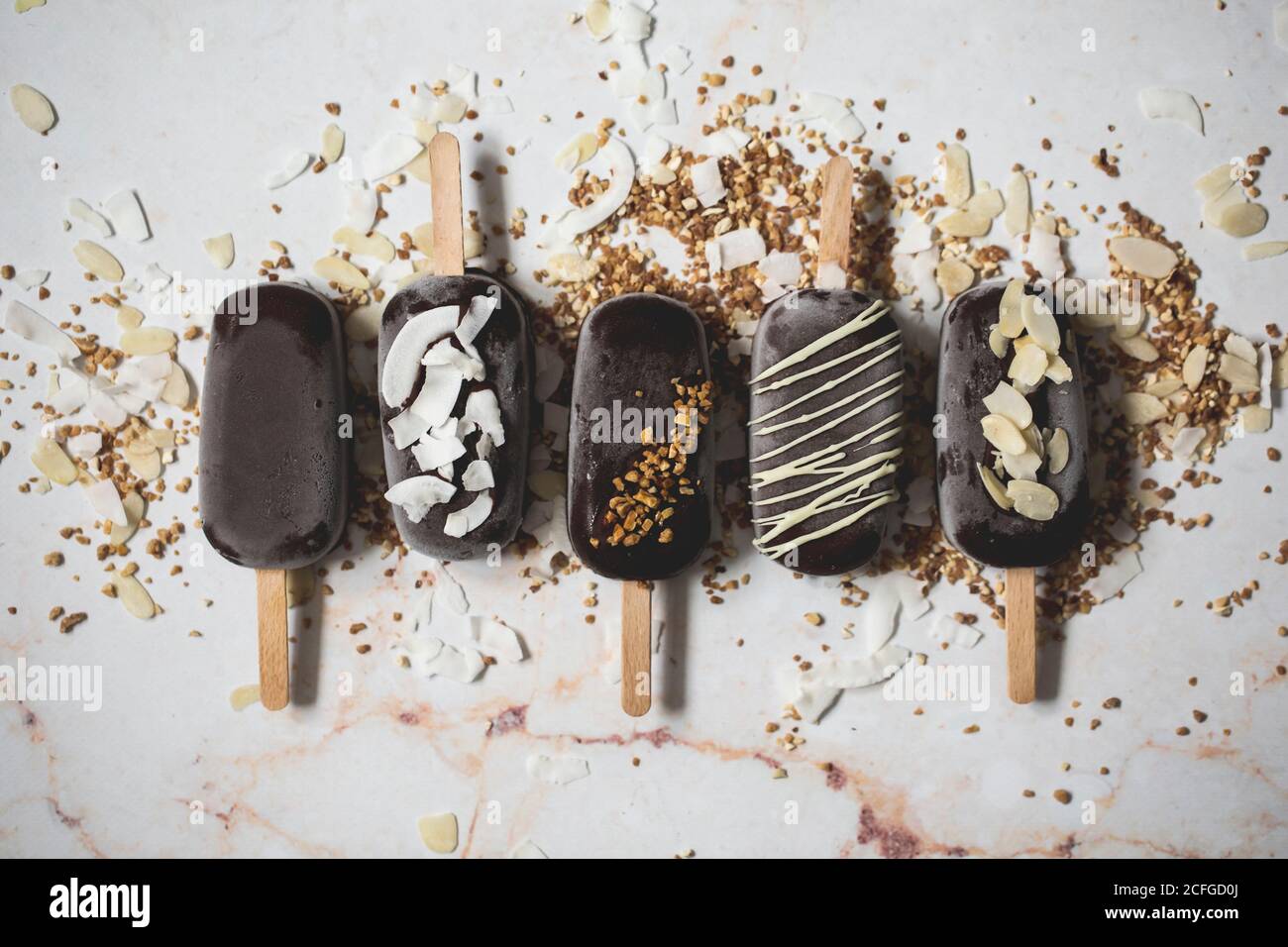 Top view of assorted chocolate ice cream popsicles covered with ...