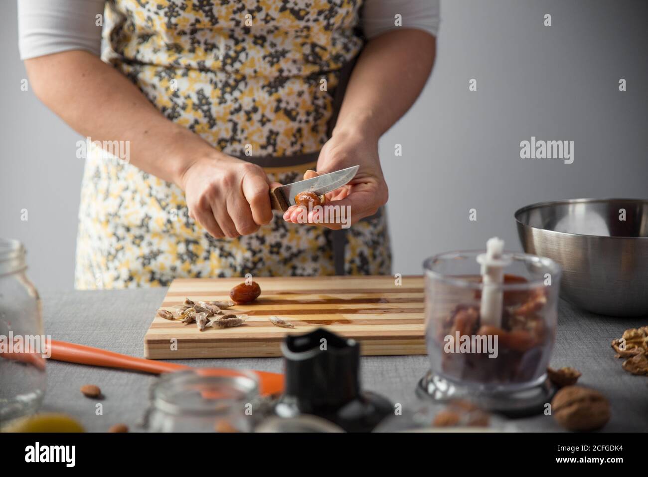 Woman cutting date on a wood board Stock Photo - Alamy
