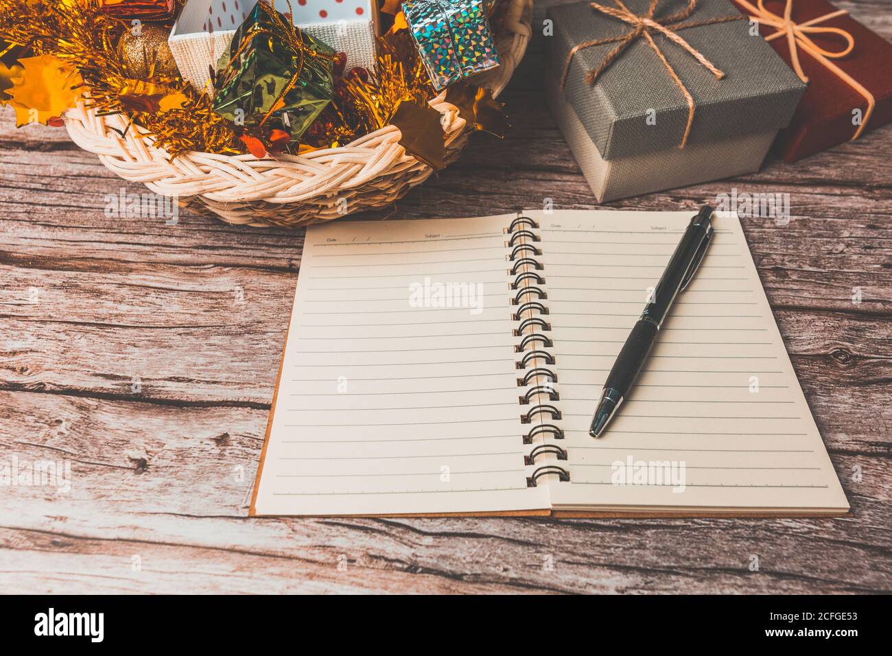 Paper note book and pen and Cristmas present box with some colorful ...