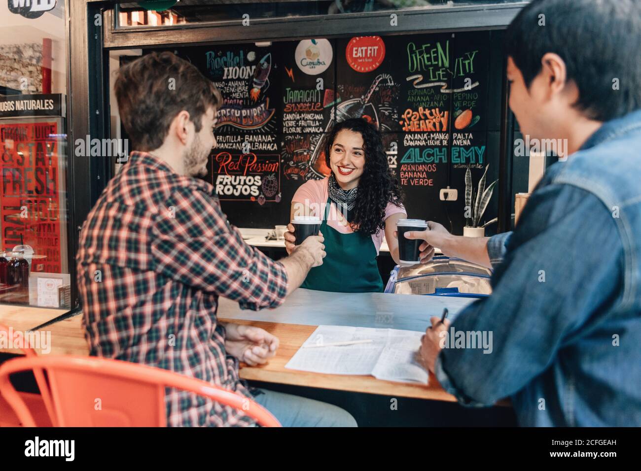 Bartender handing drink to customers Stock Photo - Alamy