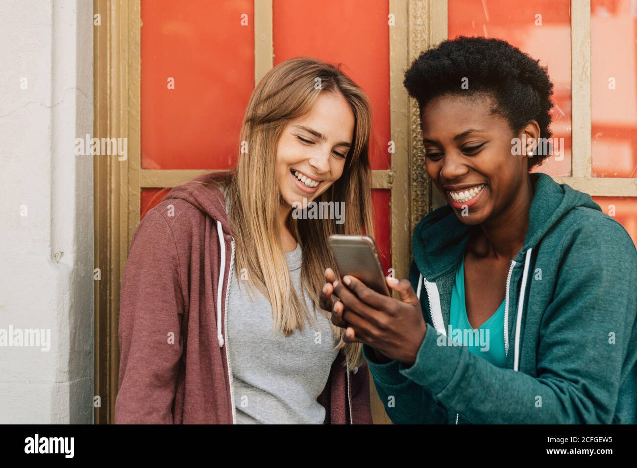 Two girls laughing a phone Stock Photo - Alamy
