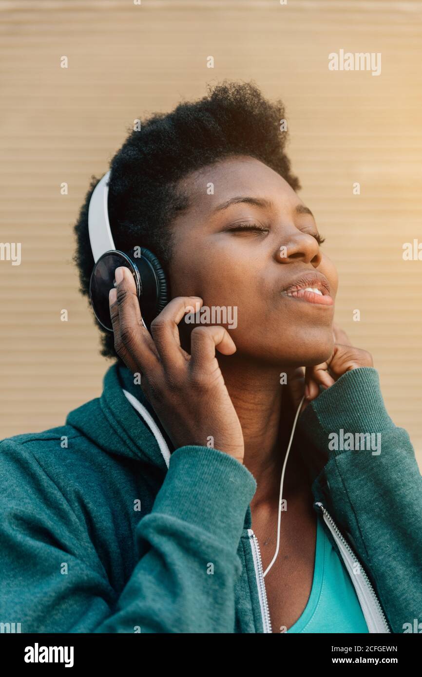 Portrait of a cute black Woman listening music on headphones Stock ...