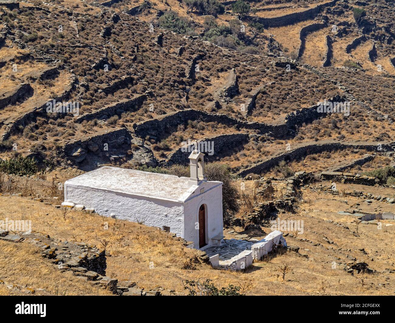 Lonely Whiteness. A small old church lays on slopes covered by dry ...