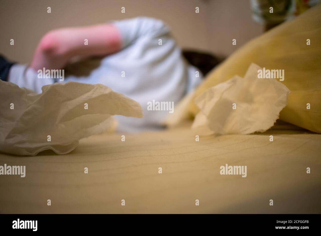 A Young Man in a White Shirt Lying in Bed Sick With Dirty Tissues Stock ...