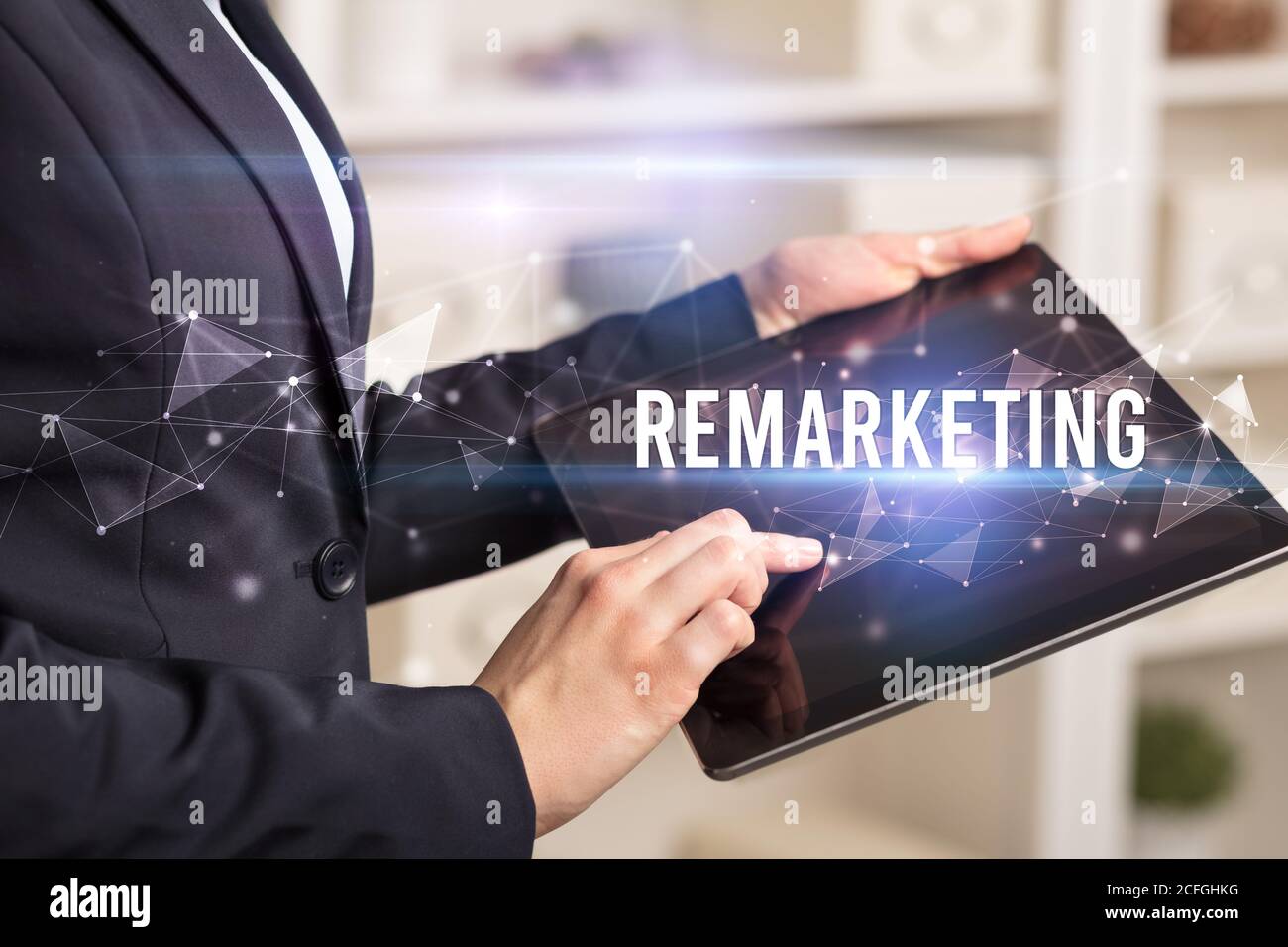 Close up hands using tablet with REMARKETING inscription, modern ...