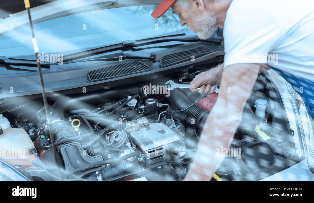 Car mechanic repairing a car engine; light effect Stock Photo - Alamy