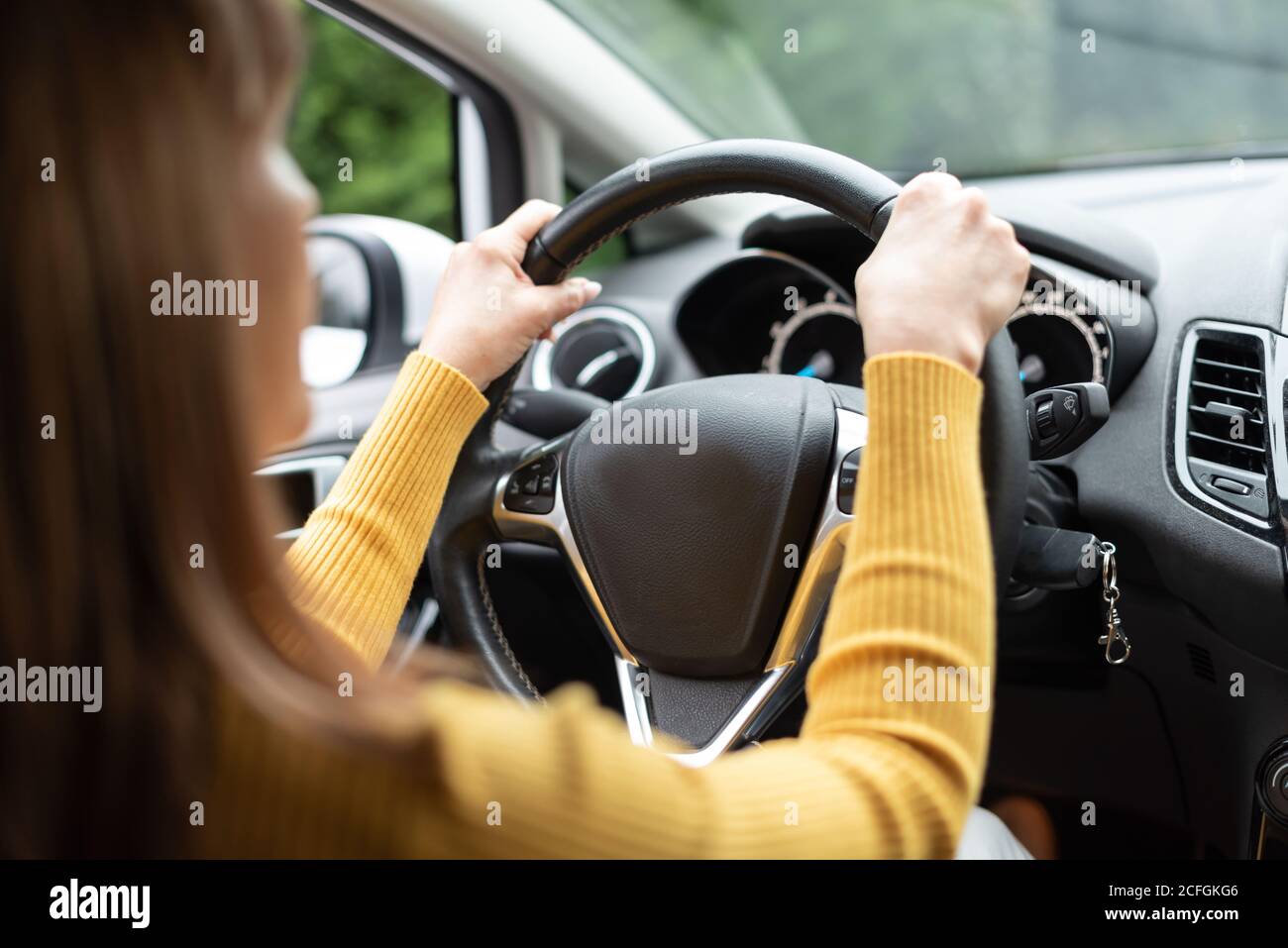 Woman driving with her two hands on steering wheel Stock Photo - Alamy