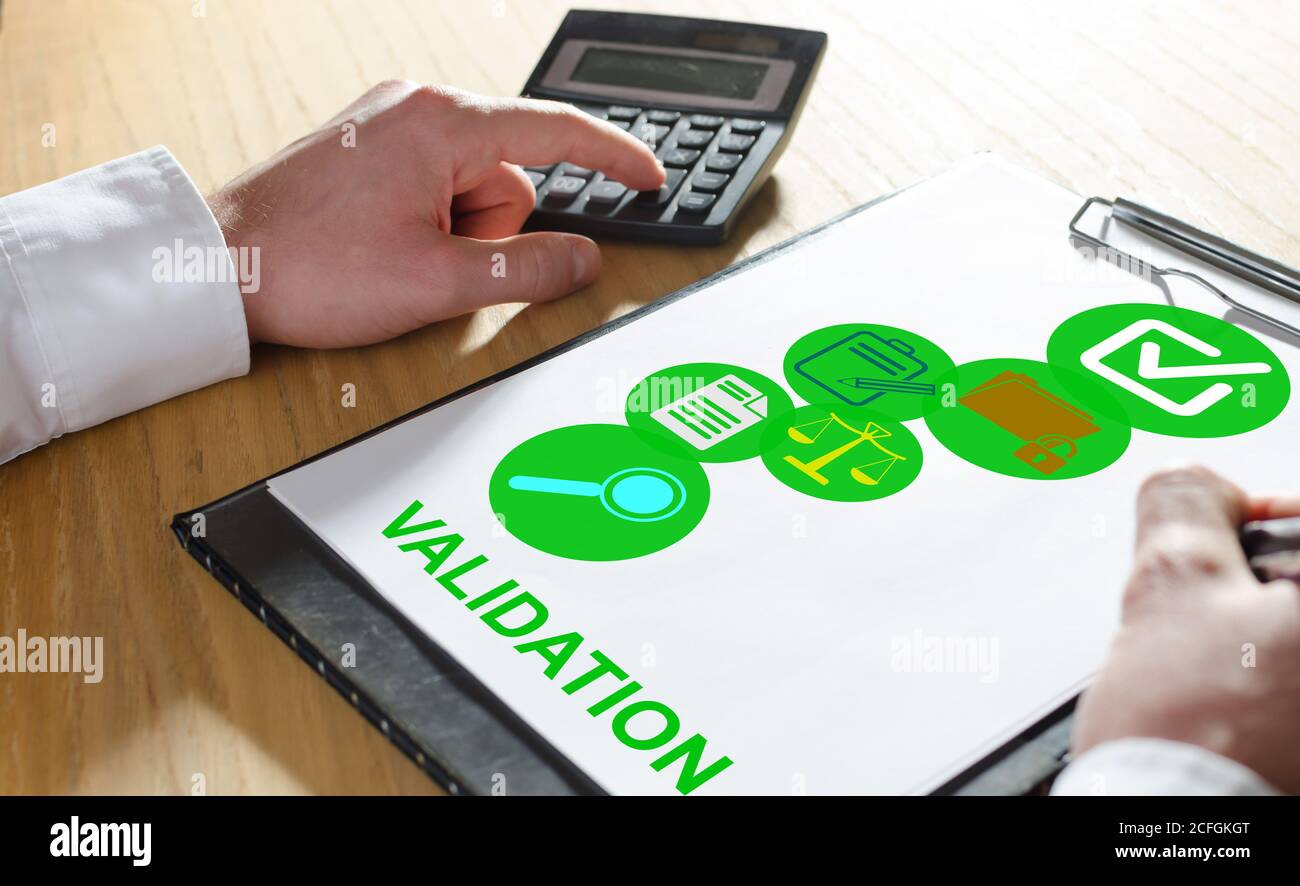 Validation concept with hand using a calculator Stock Photo - Alamy