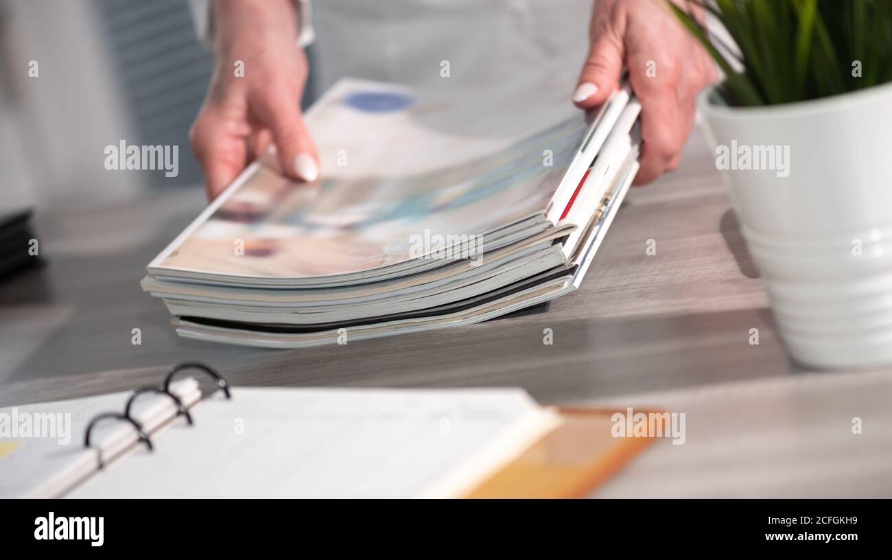 Female hands holding a stack of magazines Stock Photo - Alamy