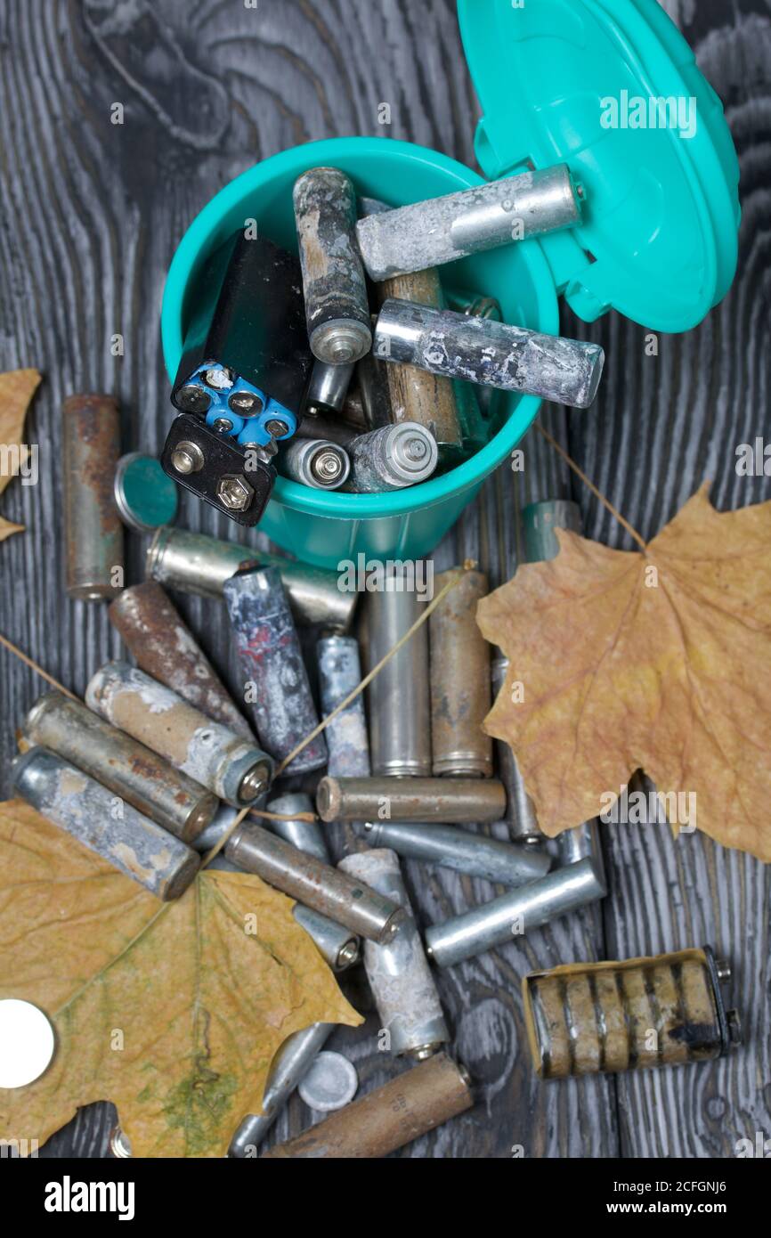 Corroded used batteries. They lie in and around the trash can. Dried ...