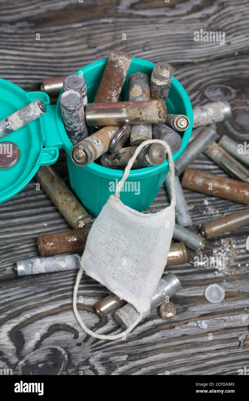 Corroded used batteries. They lie in and around the trash can. Nearby ...