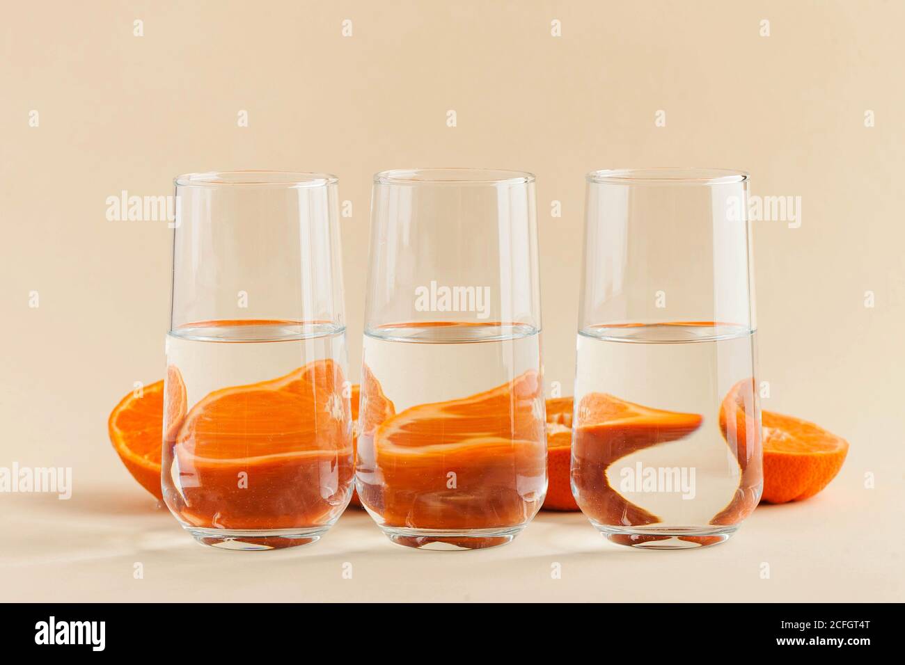 tangerine for glasses of water. Distorted image of water. Art concept ...