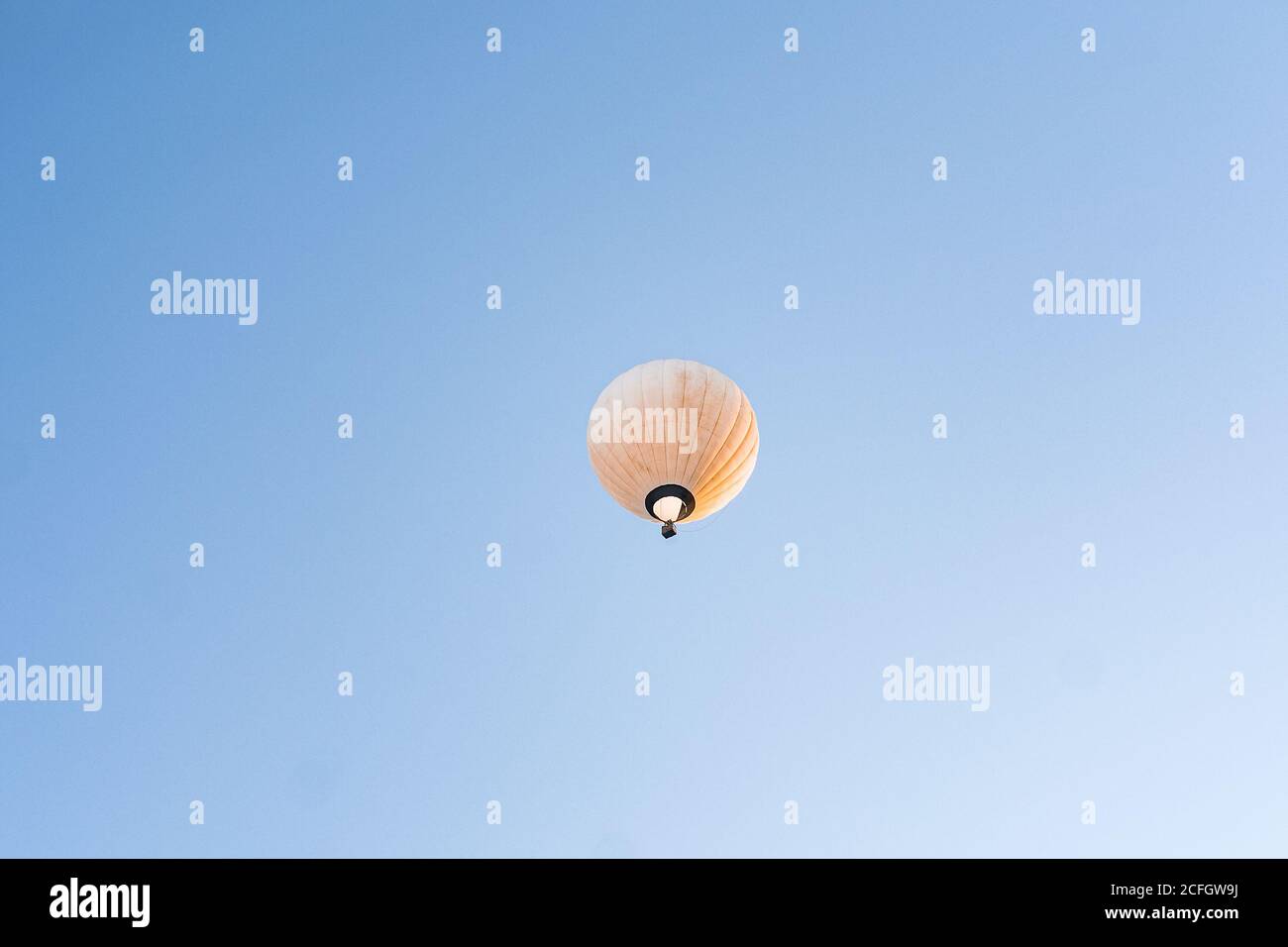Yellow hot air balloon flying in clear blue sky Stock Photo - Alamy