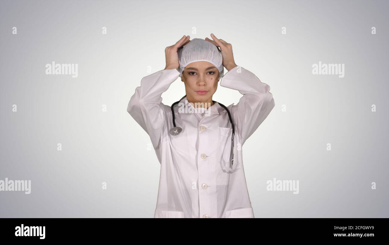 Medical doctor with stethoscope putting medical hat or cap on on ...