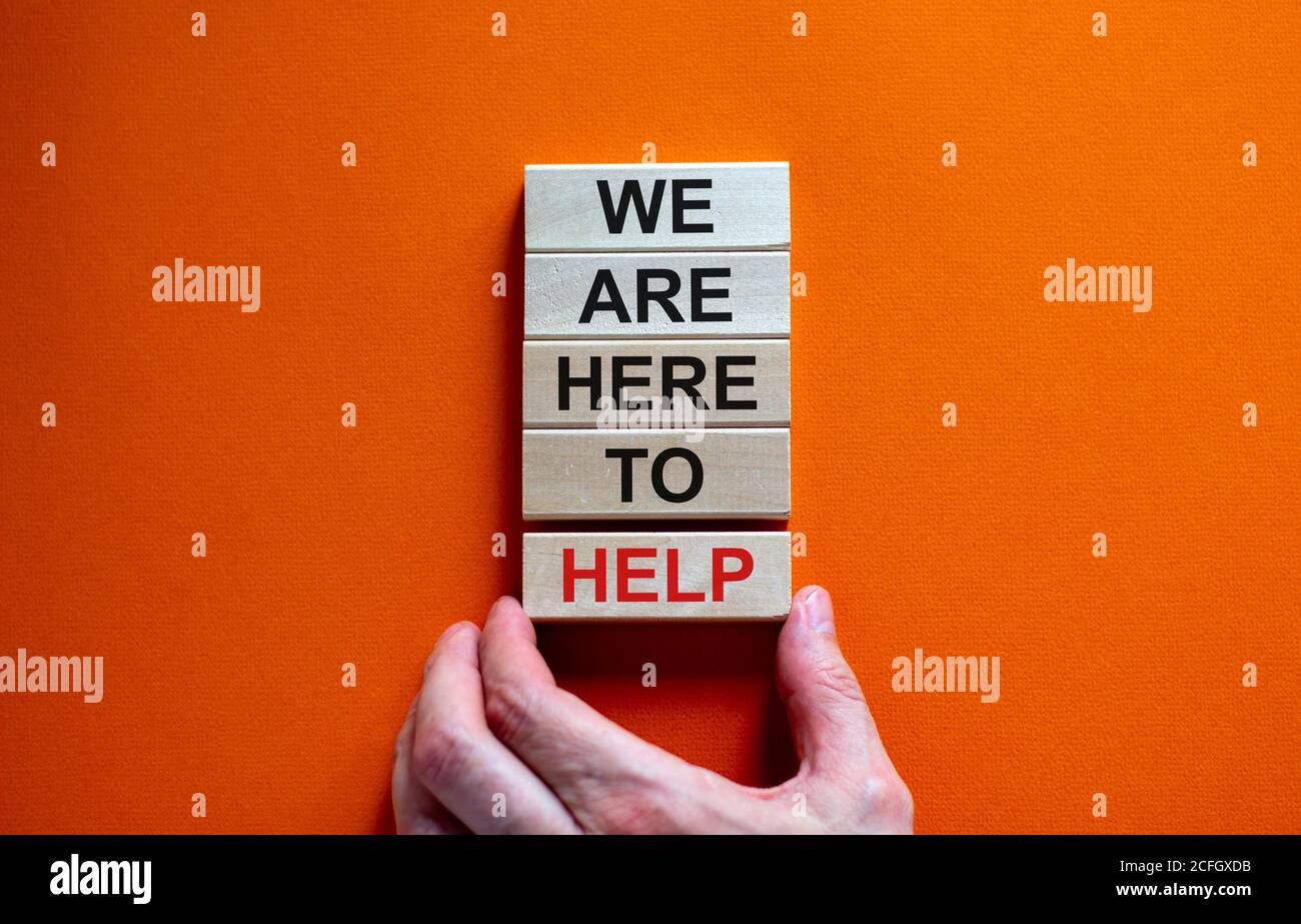 Wooden blocks with text 'we are here to help'. Male hand. Beautiful ...