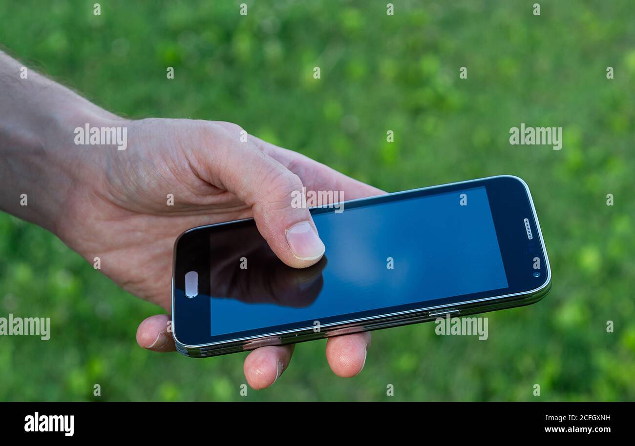 man hand holding mobile phone tap on screen Stock Photo - Alamy